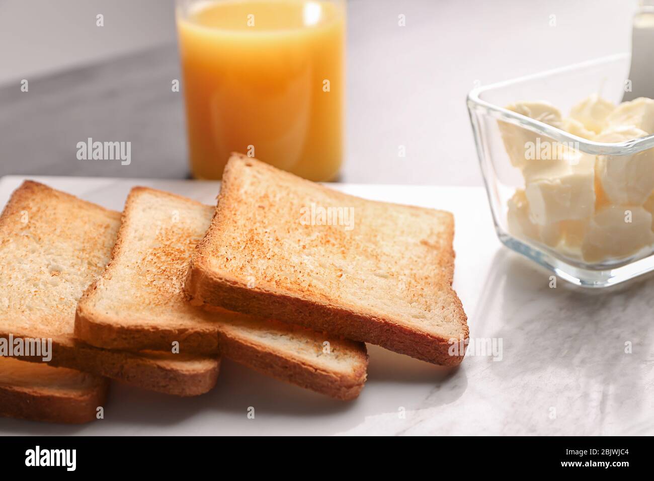 Marble board with tasty toasted bread and butter, closeup Stock Photo ...
