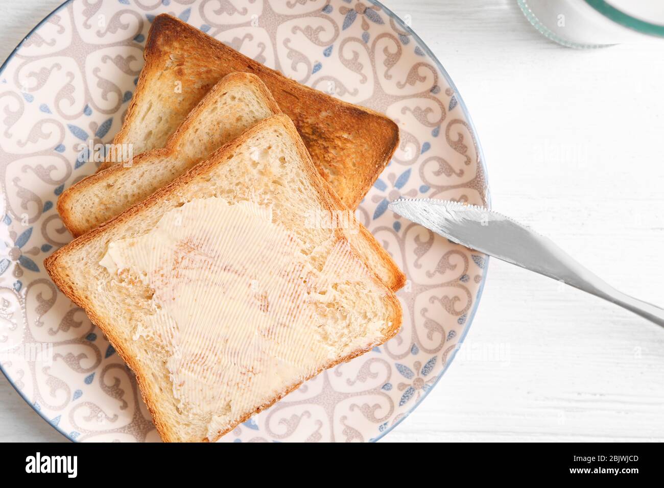 Tasty toasted bread with butter on plate Stock Photo - Alamy