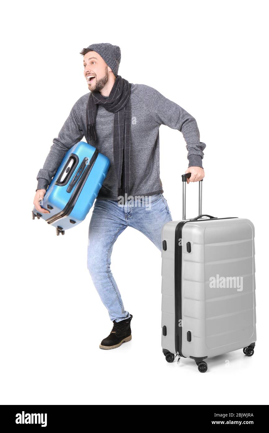 Young man with luggage running on white background. Ready for winter ...