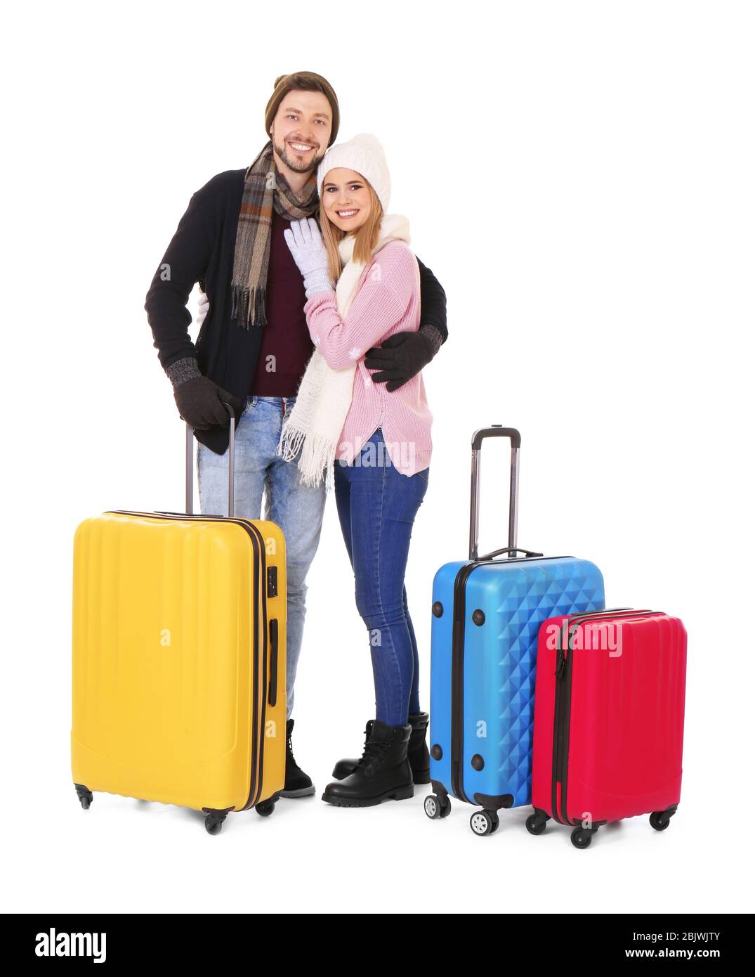 Young couple with luggage on white background. Ready for winter ...
