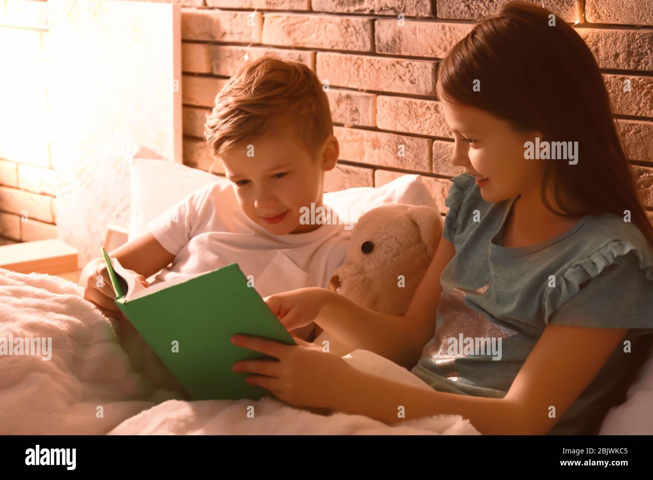 Cute little brother and sister reading bedtime story in evening Stock ...