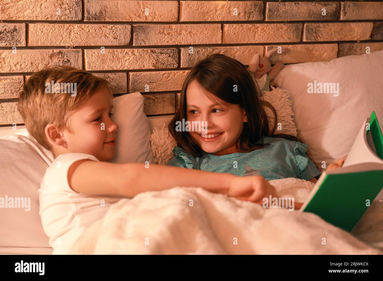 Cute little brother and sister reading bedtime story in evening Stock ...