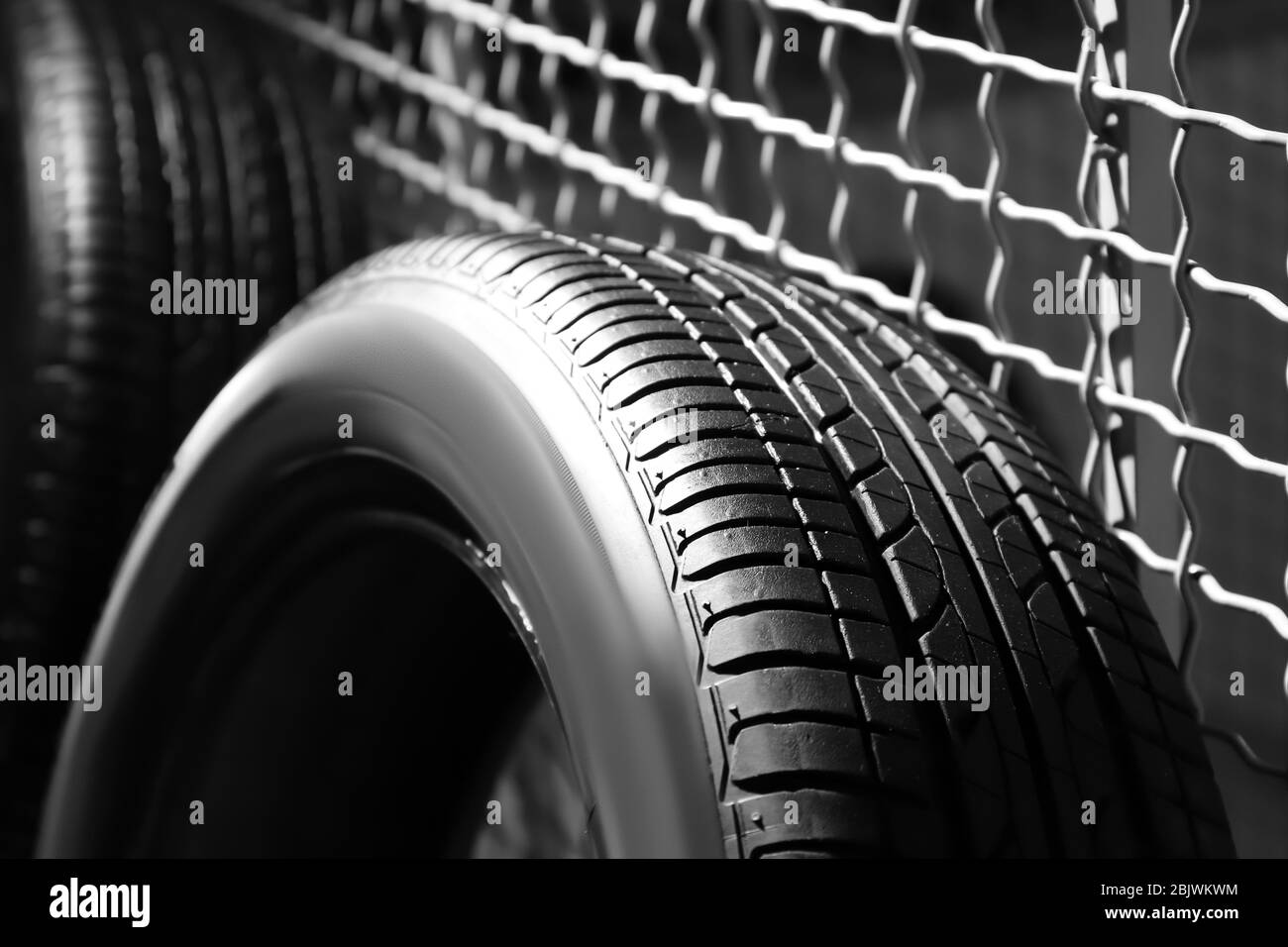 Car tire near grate fence indoors Stock Photo - Alamy