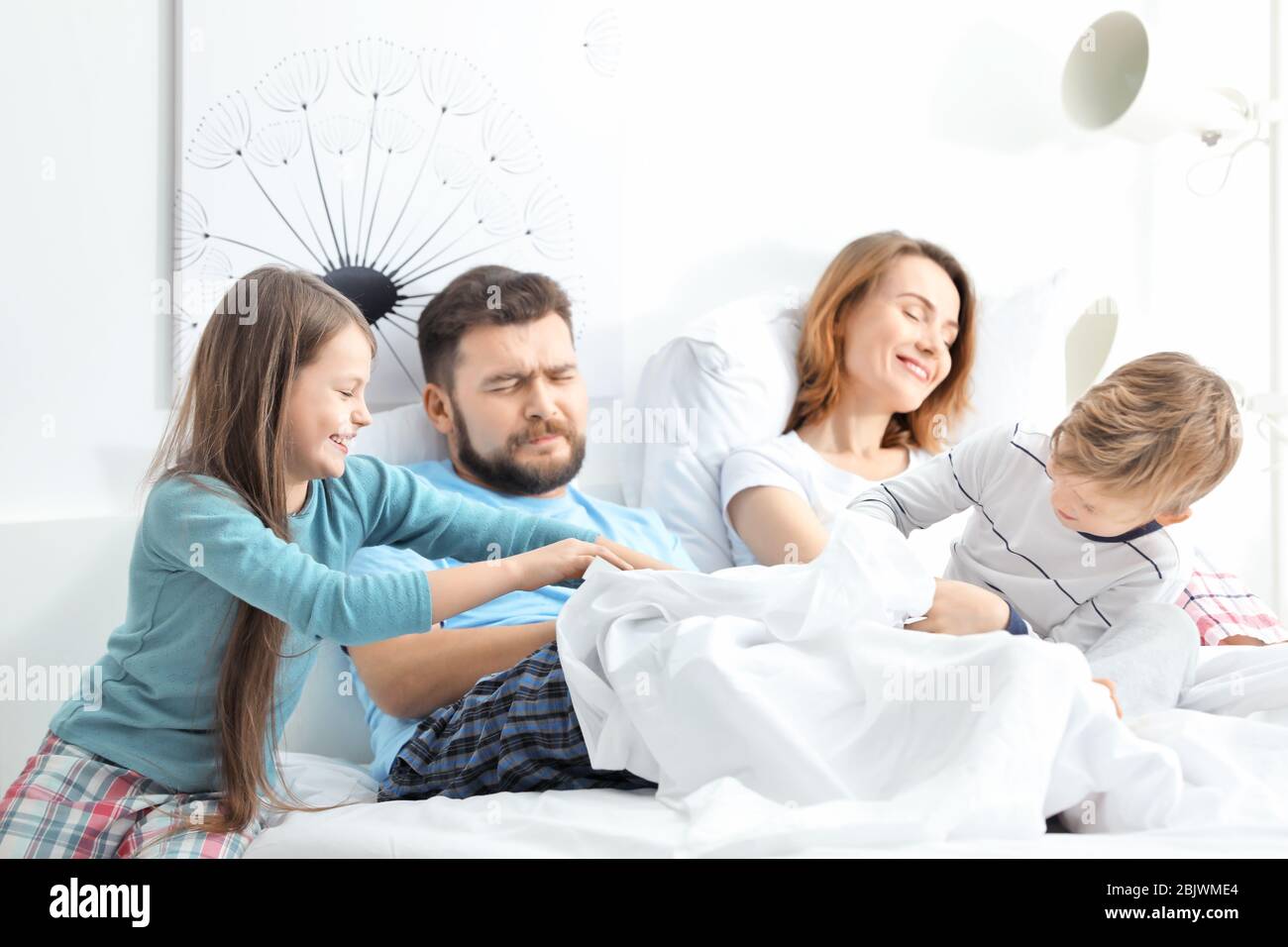 Children waking up their parents in bedroom Stock Photo - Alamy