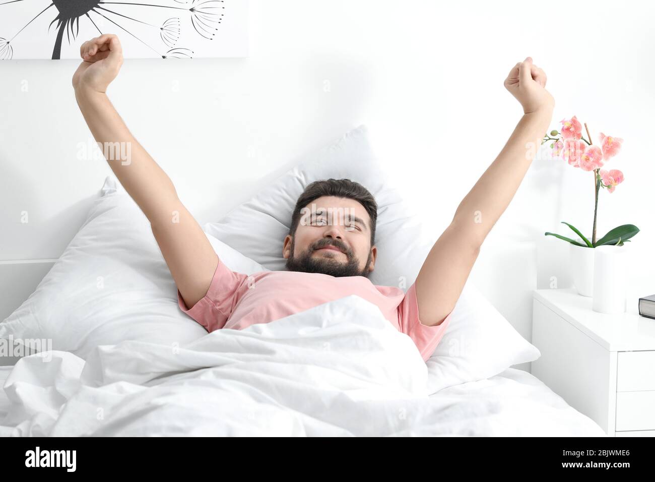 Morning of man stretching in bed at home Stock Photo - Alamy