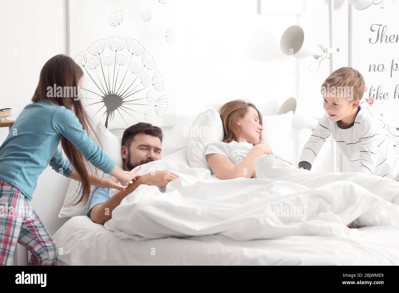 Children waking up their parents in bedroom Stock Photo - Alamy