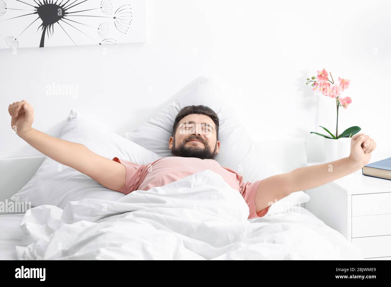 Morning of man stretching in bed at home Stock Photo - Alamy