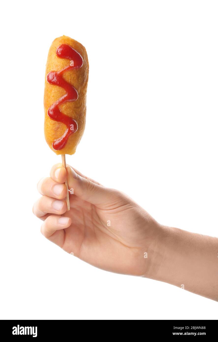 Woman holding tasty corn dog with ketchup on white background Stock ...