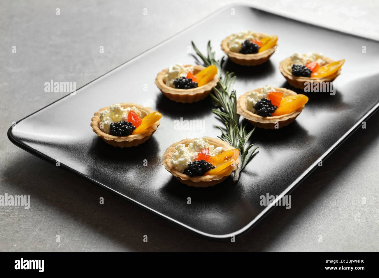Delicious canapes with black caviar on plate Stock Photo - Alamy