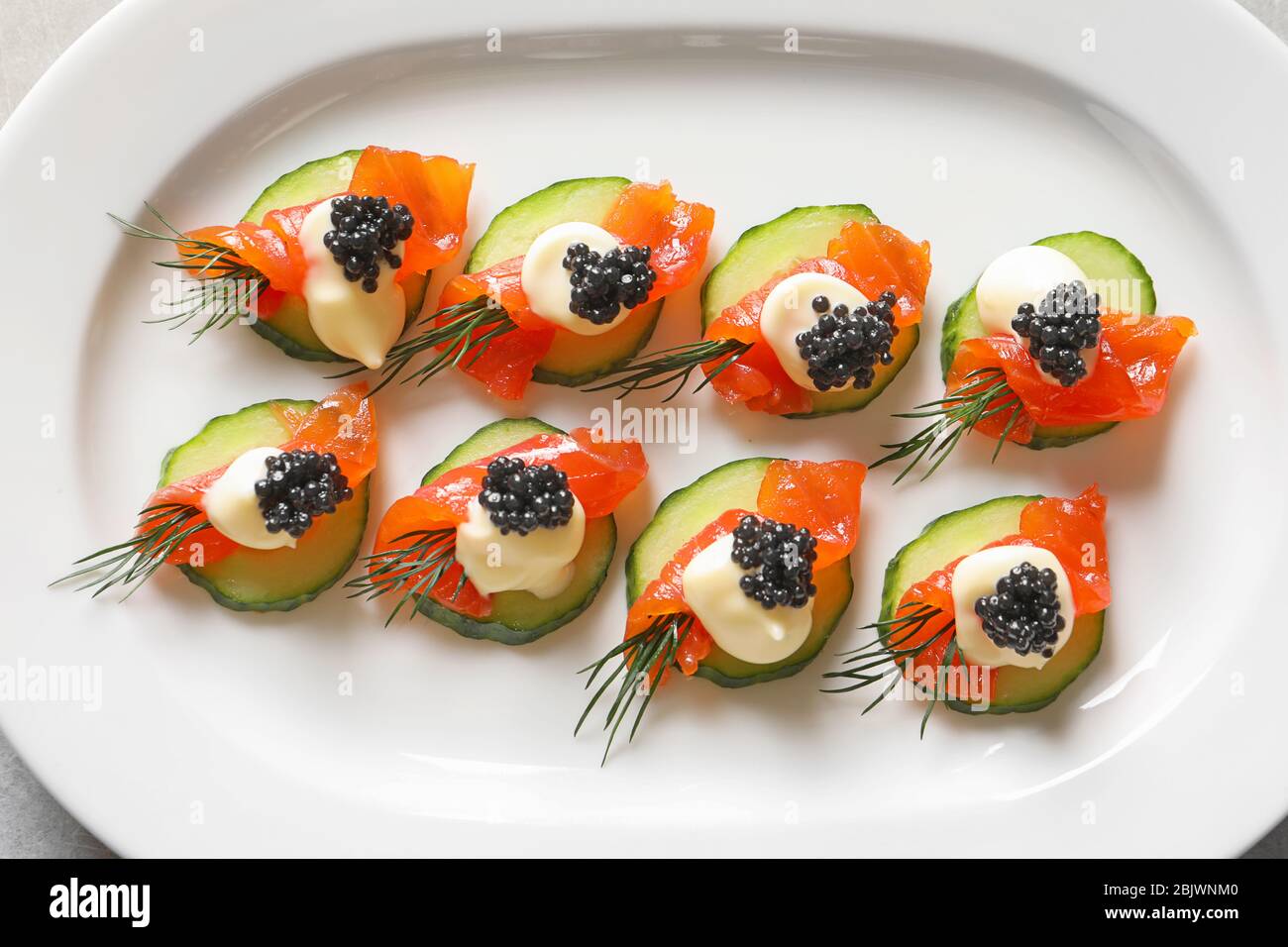 Delicious canapes with black caviar on plate Stock Photo - Alamy