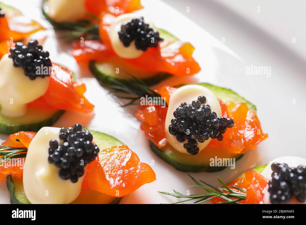 Delicious canapes with black caviar on plate, closeup Stock Photo - Alamy