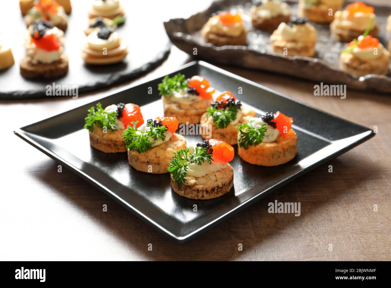 Delicious canapes with black caviar on plate Stock Photo - Alamy