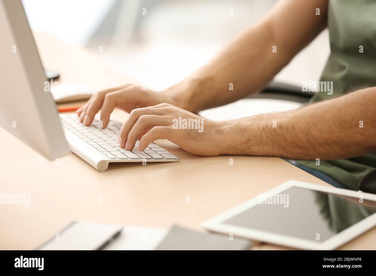 Man working with computer at table in office, closeup Stock Photo - Alamy