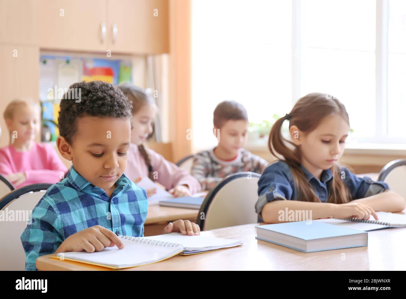 Cute children doing homework in classroom at school Stock Photo - Alamy