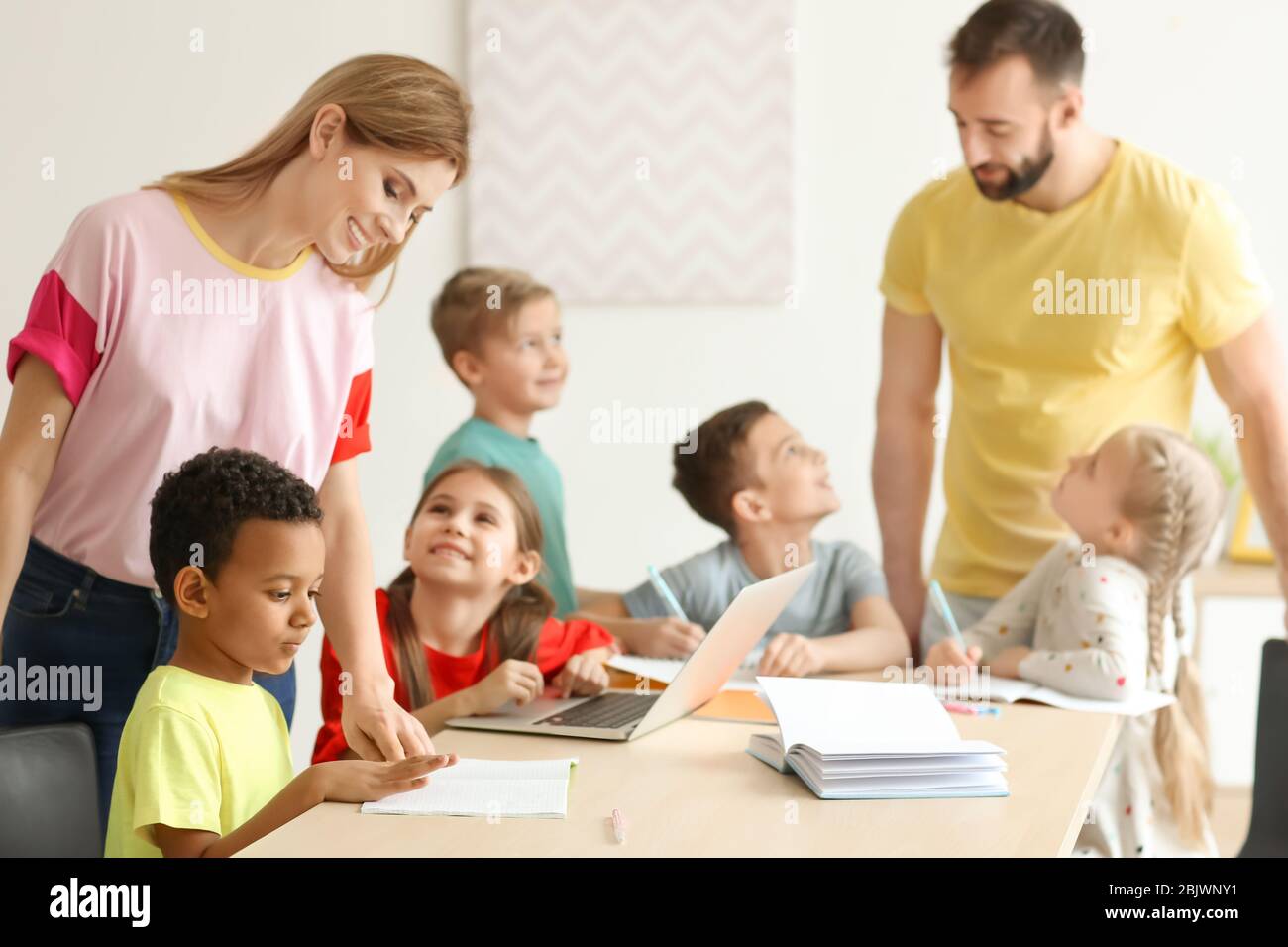 Teachers helping children with homework in classroom at school Stock ...
