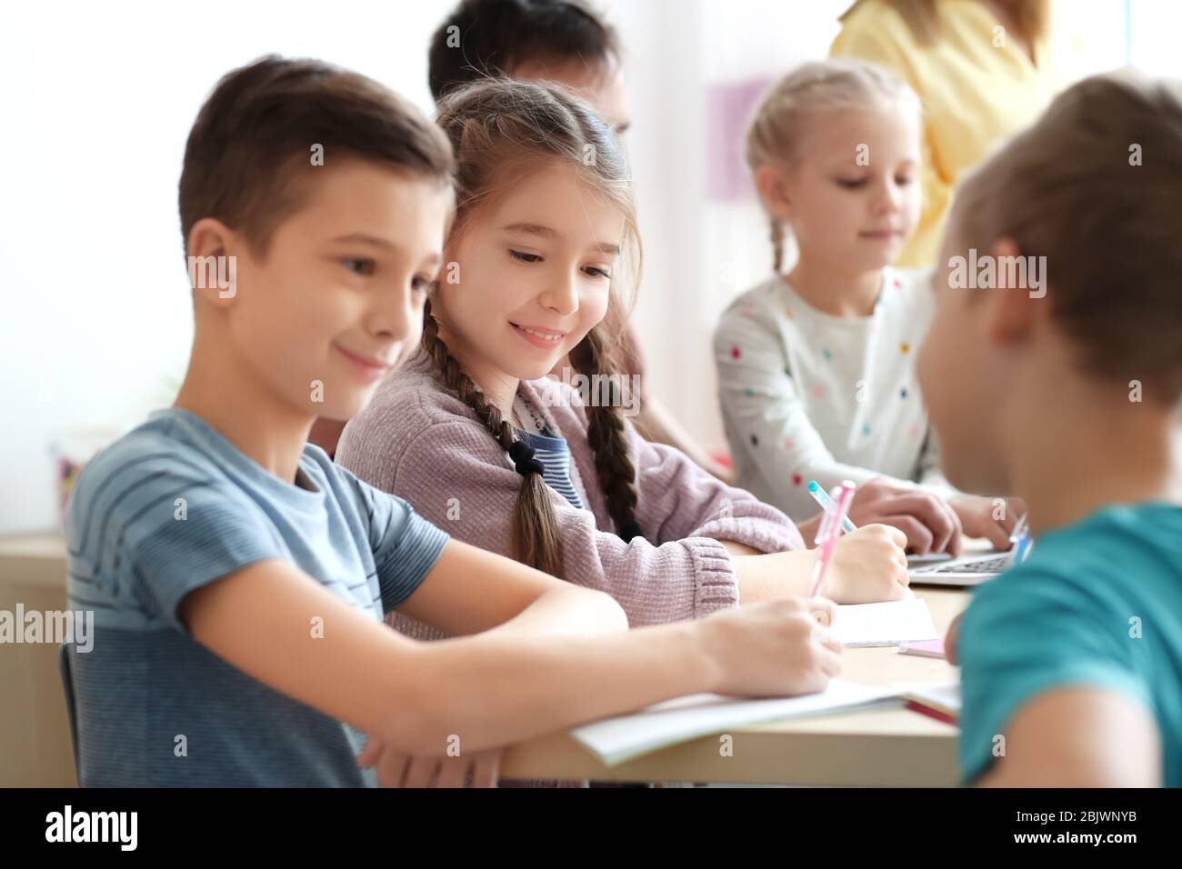 Cute children doing homework in classroom at school Stock Photo - Alamy