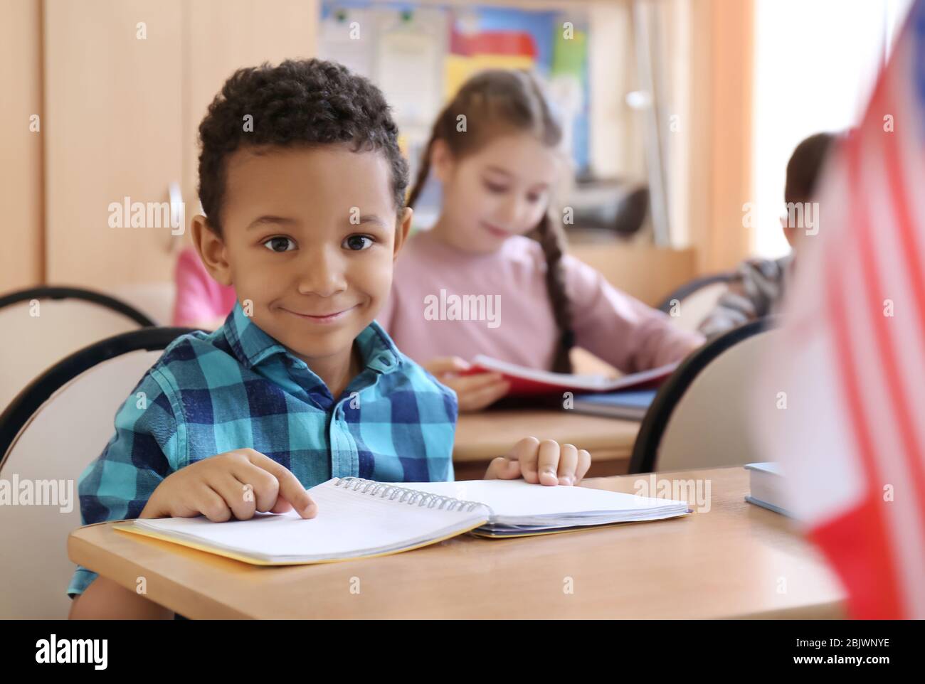 Cute African American boy doing homework in classroom at school Stock ...