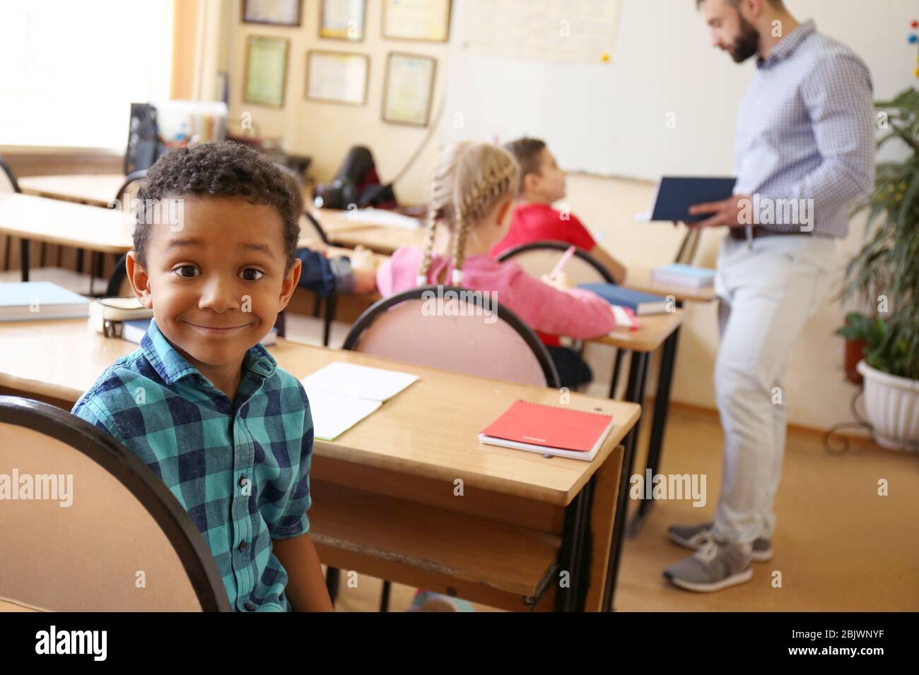 Cute African American boy doing homework in classroom at school Stock ...