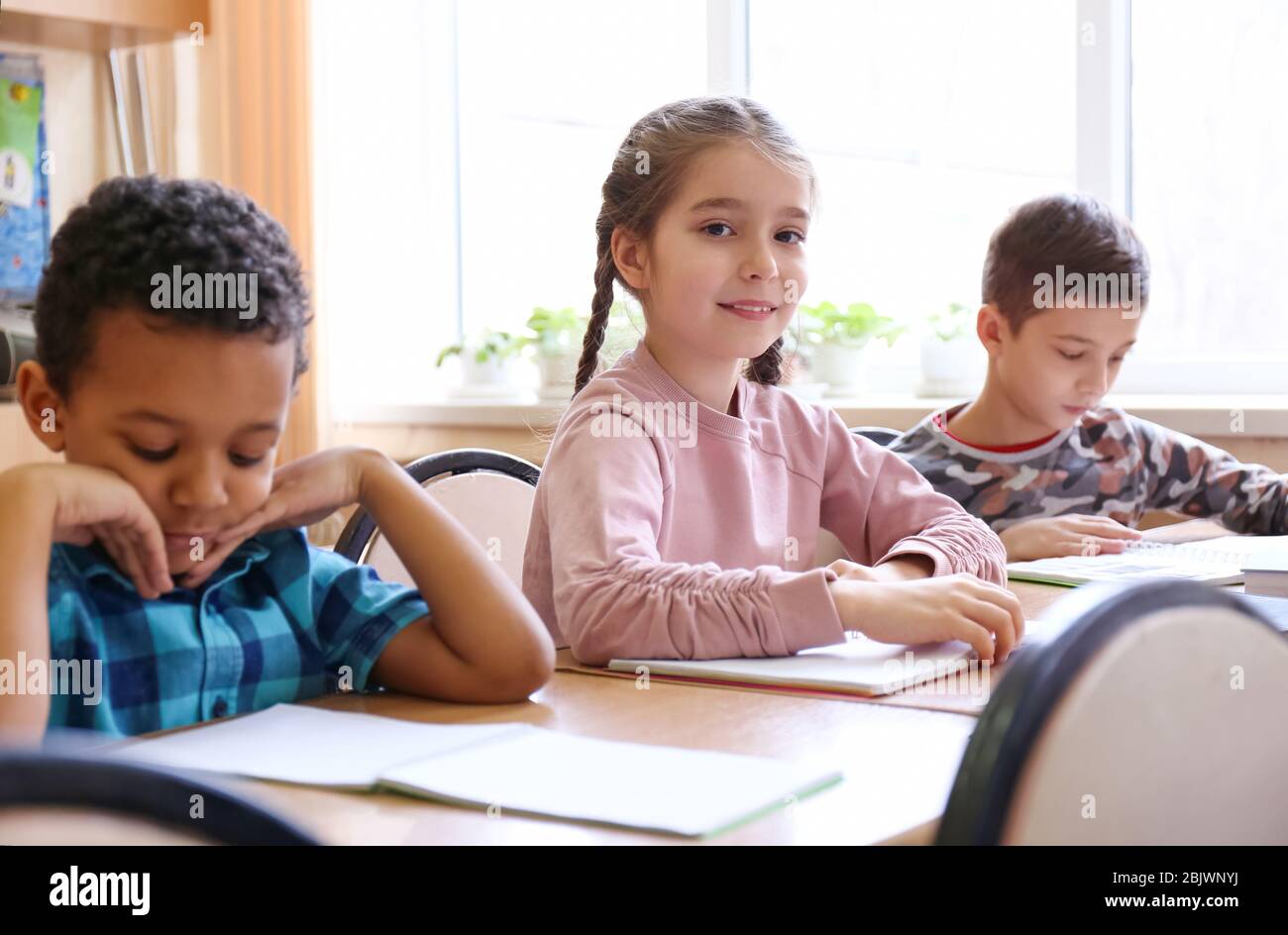 Cute children doing homework in classroom at school Stock Photo - Alamy