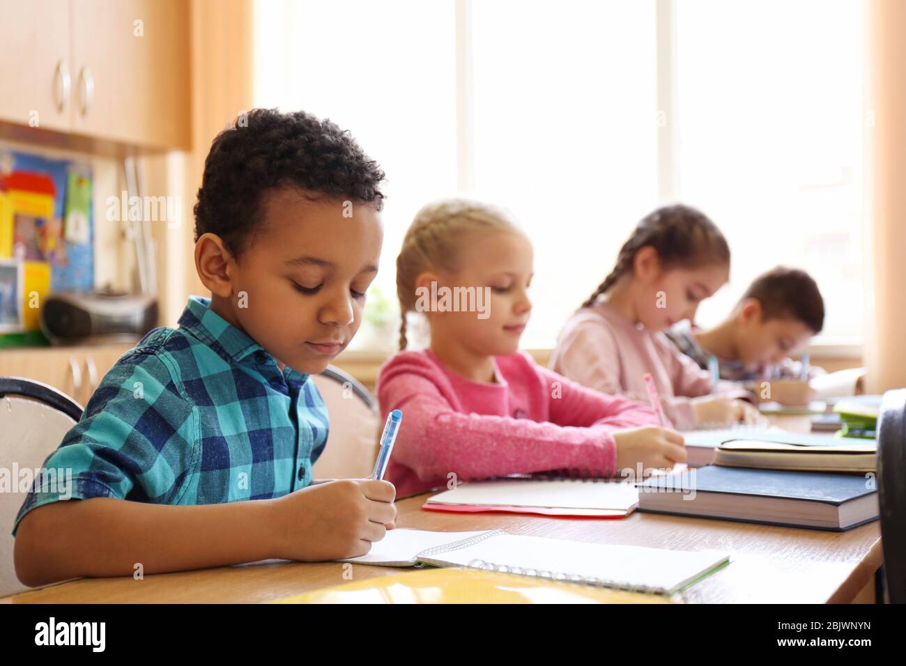 Cute children doing homework in classroom at school Stock Photo - Alamy