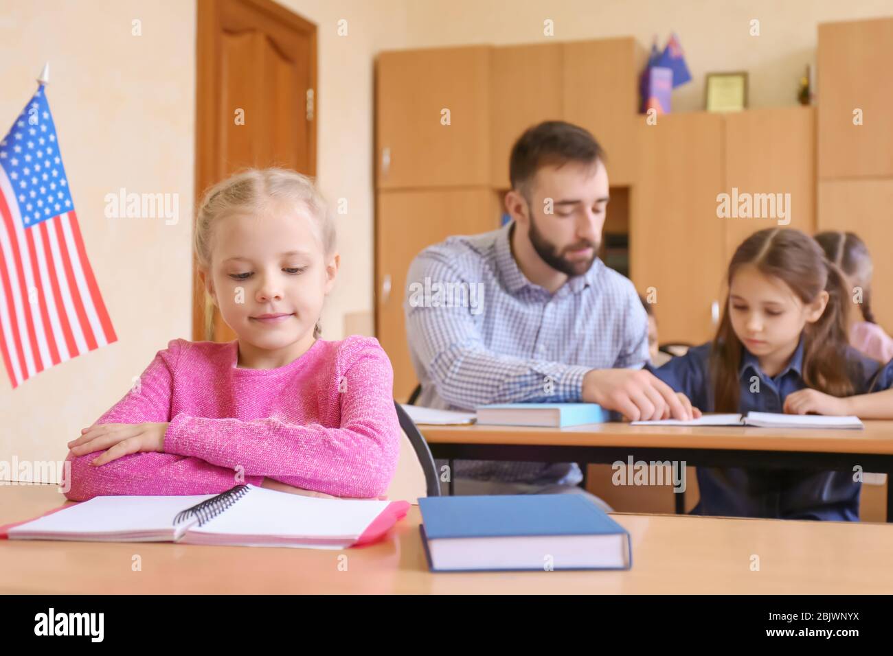 Cute girl doing homework in classroom at school Stock Photo - Alamy