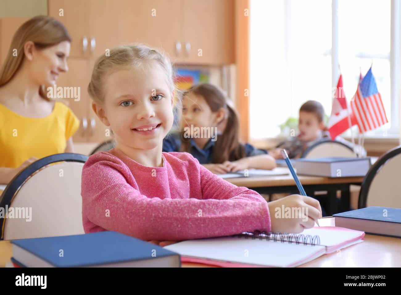 Cute girl doing homework in classroom at school Stock Photo - Alamy
