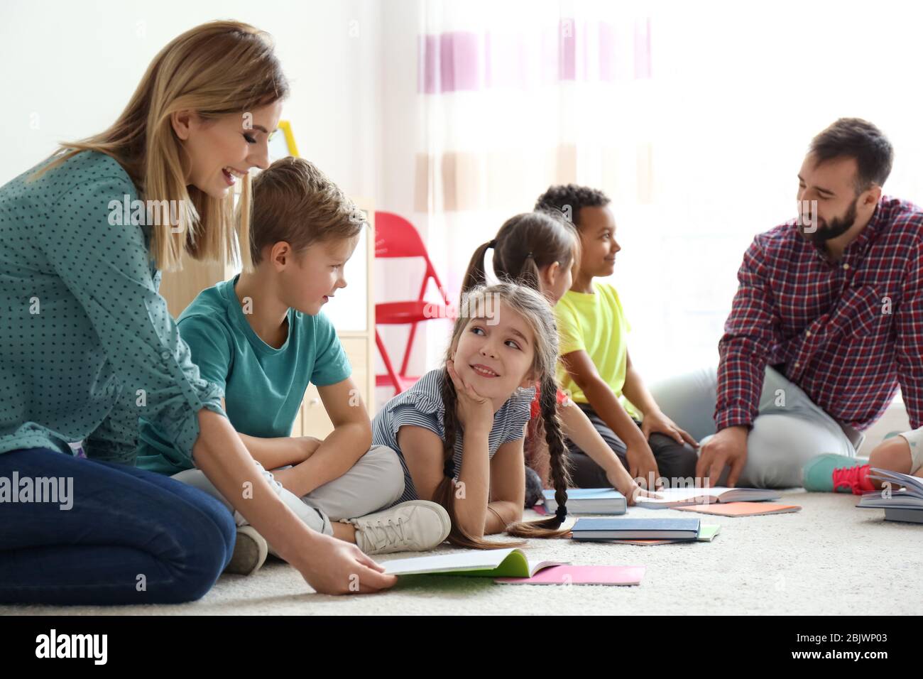 Teachers helping children with homework in classroom at school Stock ...
