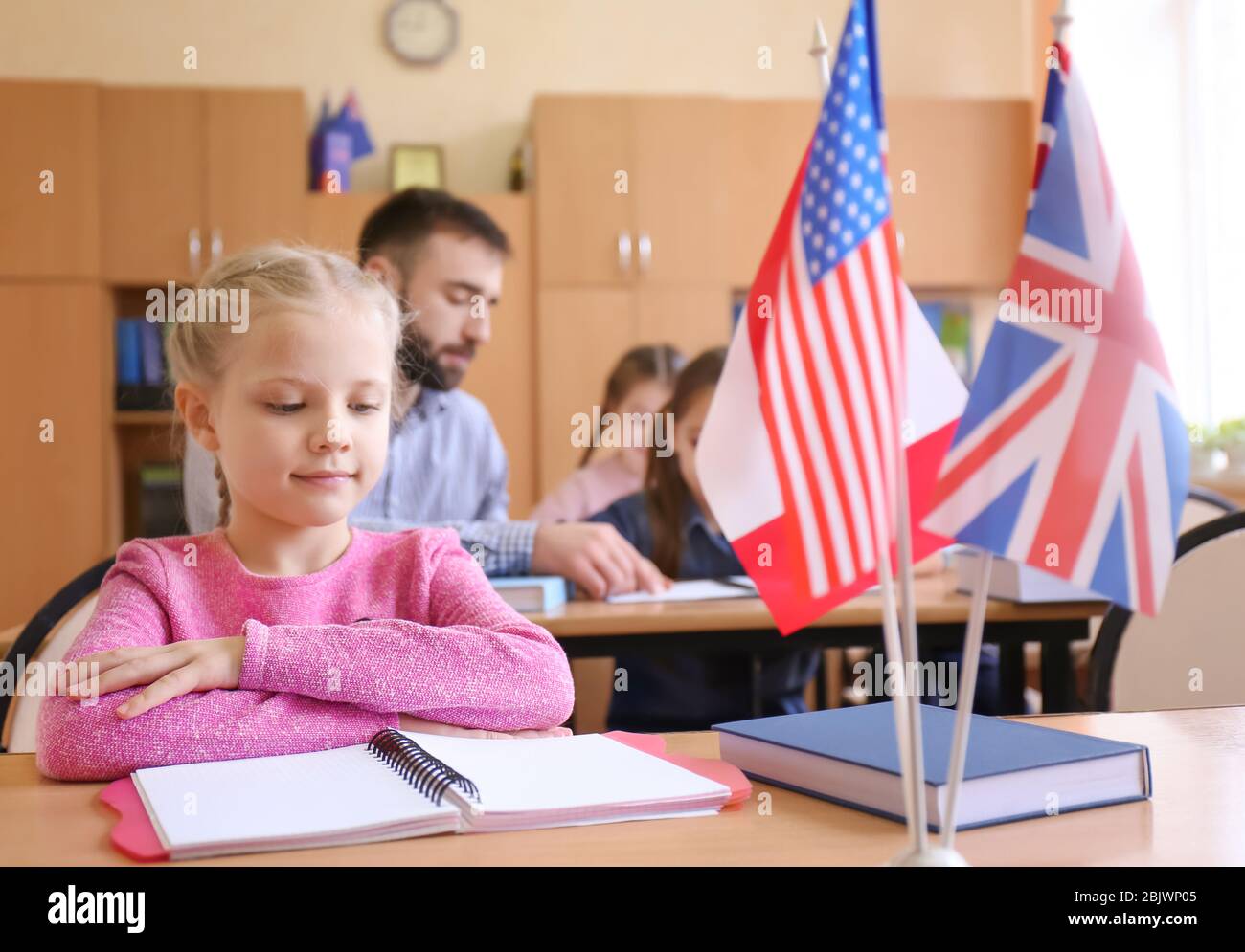 Cute girl doing homework in classroom at school Stock Photo - Alamy