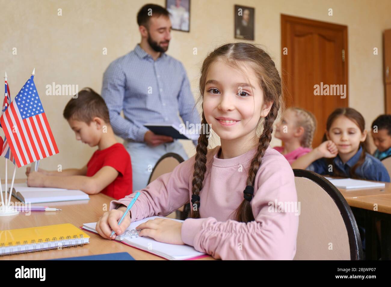 Cute girl doing homework in classroom at school Stock Photo - Alamy