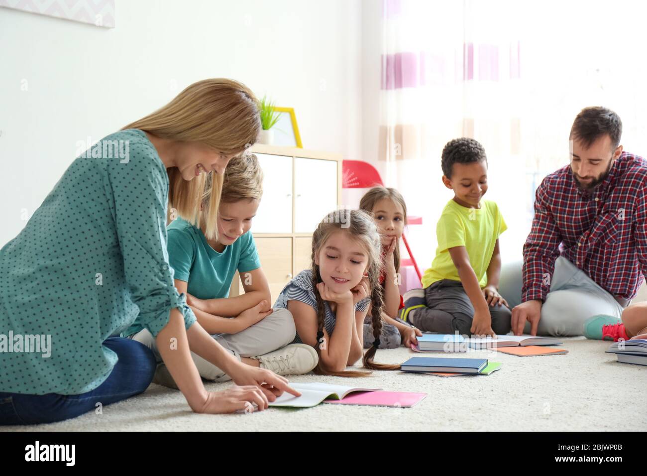 Teachers helping children with homework in classroom at school Stock ...