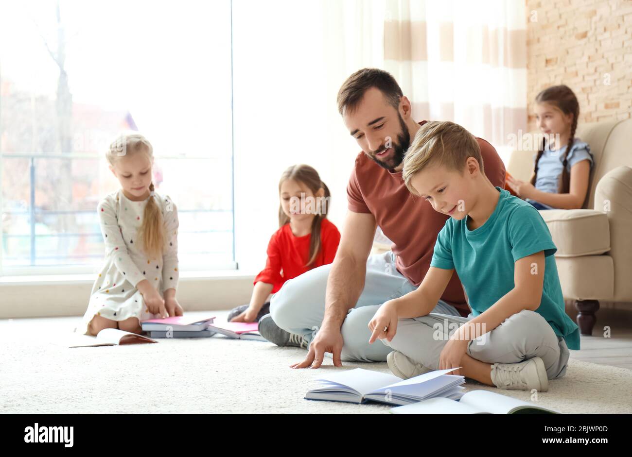 Male teacher helping boy with his homework in classroom at school Stock ...