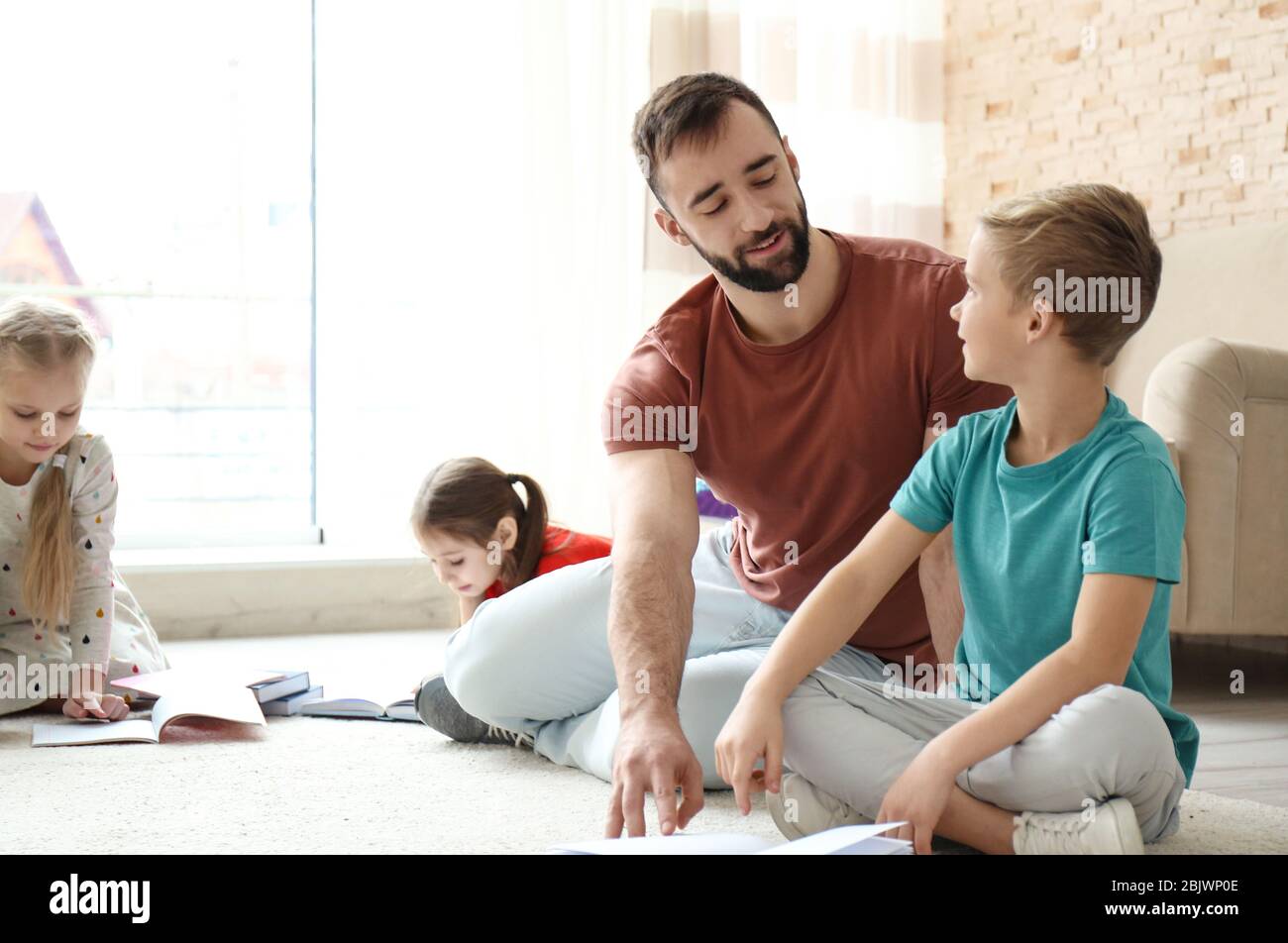 Male teacher helping boy with his homework in classroom at school Stock ...