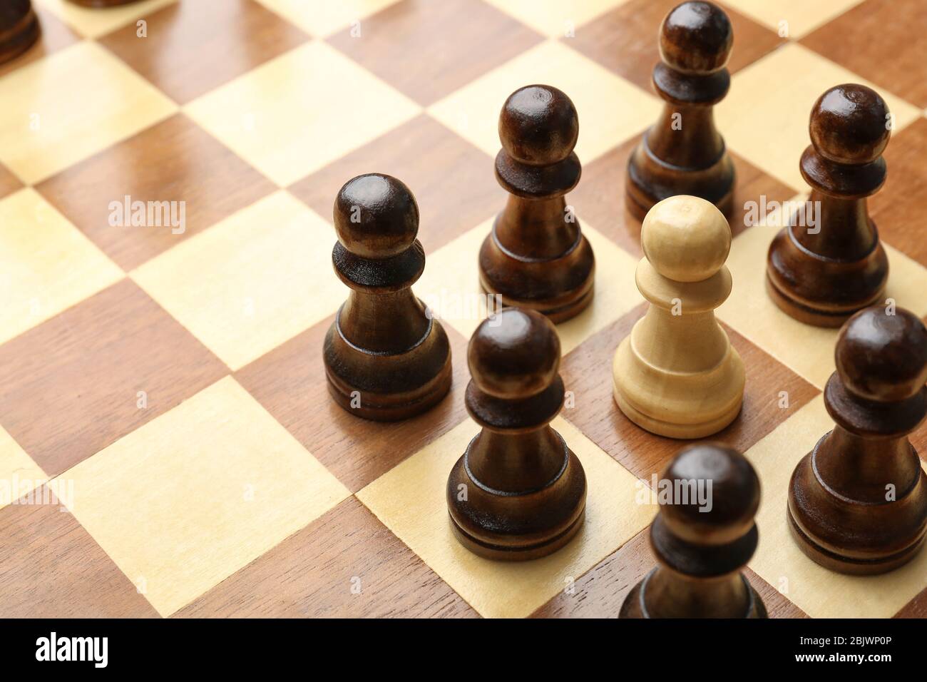 Wooden chess figures and one different on board Stock Photo - Alamy