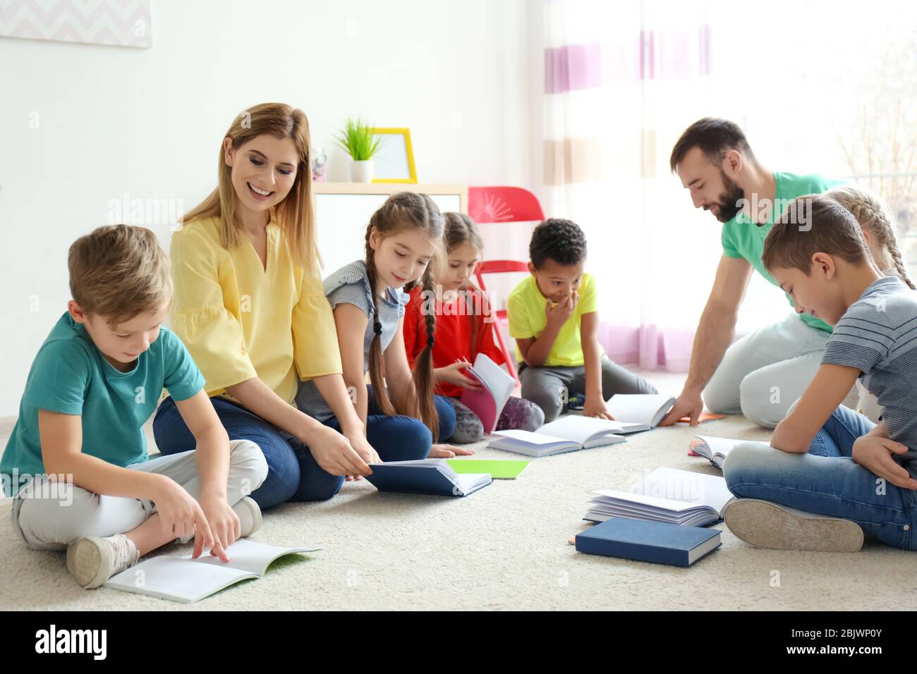 Teachers helping children with homework in classroom at school Stock ...