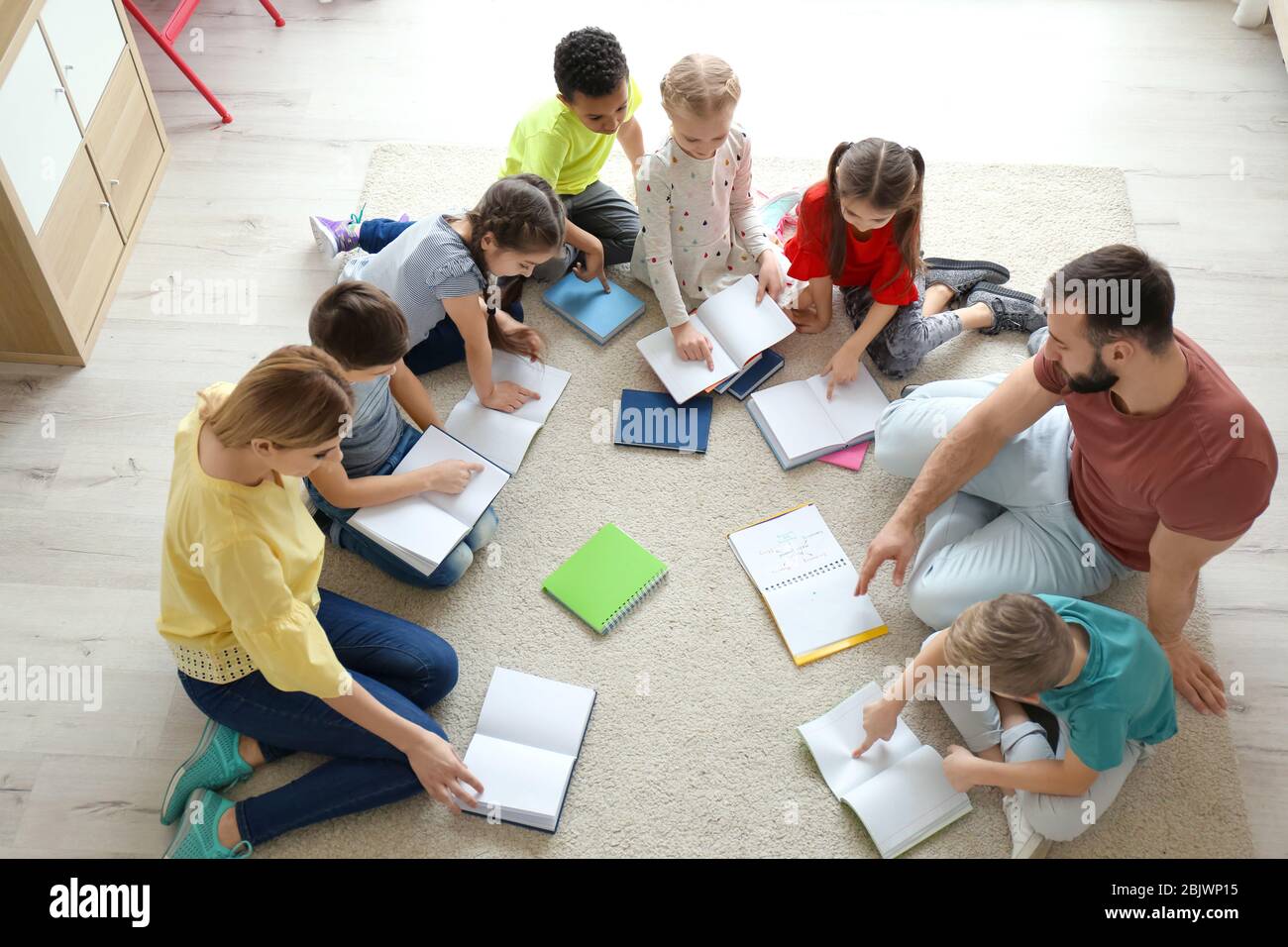 Teachers helping children with homework in classroom at school Stock ...