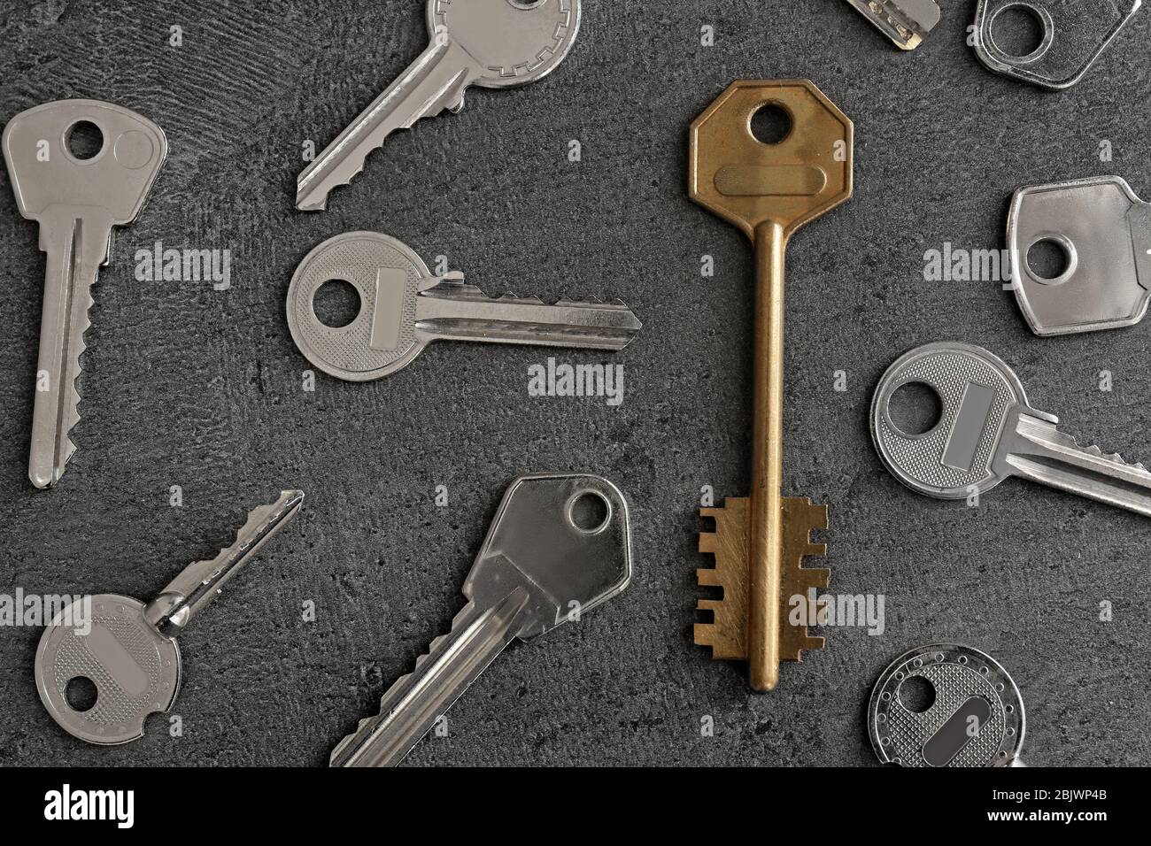 Keys and one different on grey background Stock Photo - Alamy