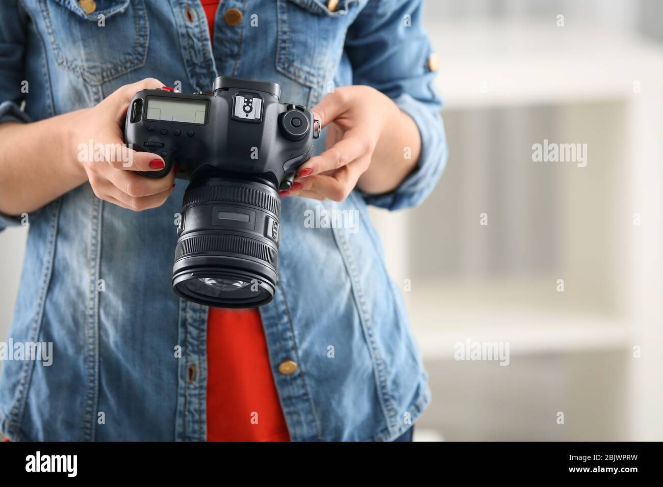 Young photographer with camera, indoors Stock Photo - Alamy