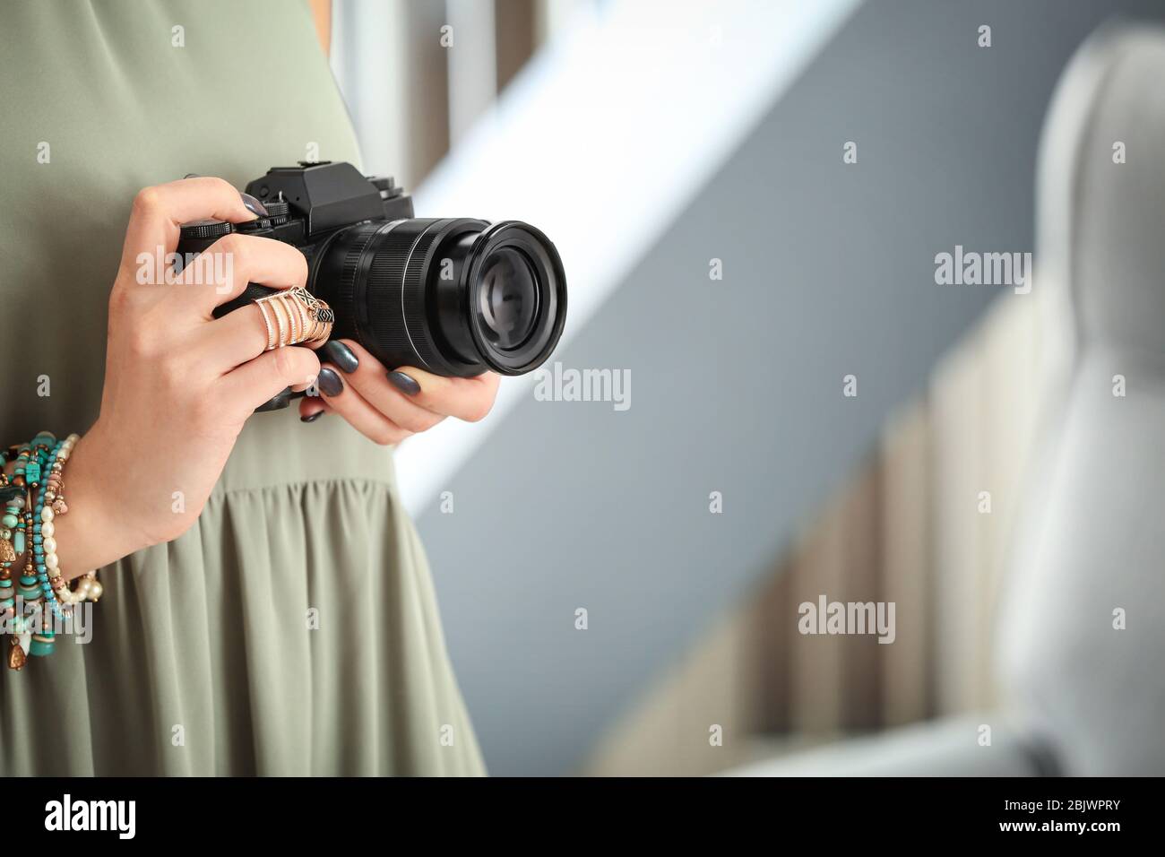 Young photographer with camera, indoors Stock Photo - Alamy