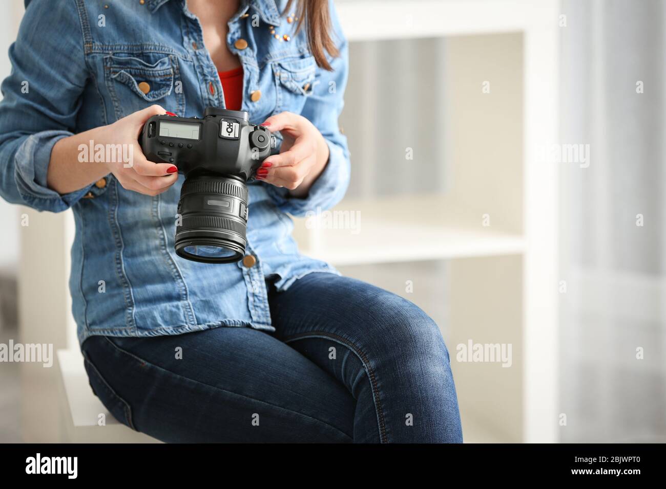 Young photographer with camera, indoors Stock Photo - Alamy