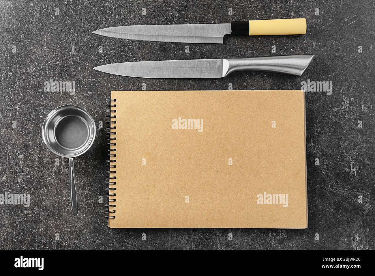 Notebook and kitchen utensils on grey background. Cooking master ...