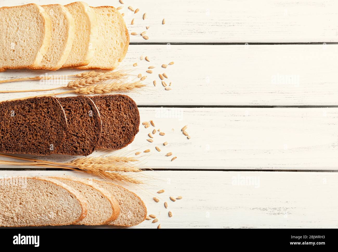 Flat lay composition with bread slices and spikes on wooden background ...