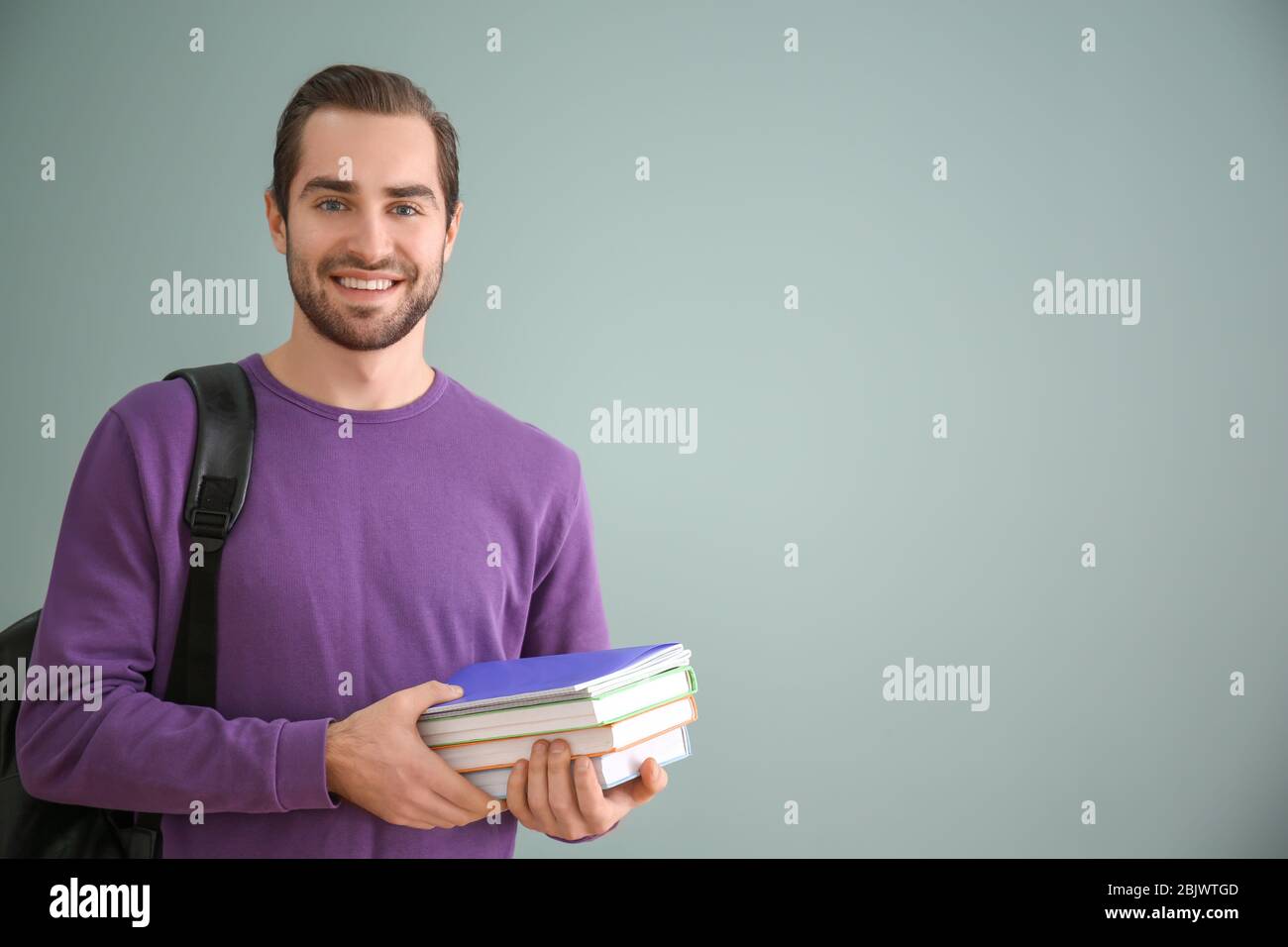 Student with notebooks on color background Stock Photo - Alamy