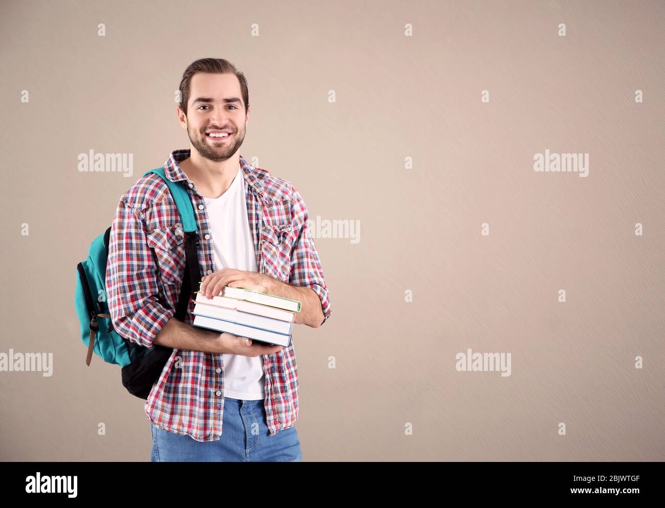 Student with notebooks on color background Stock Photo - Alamy