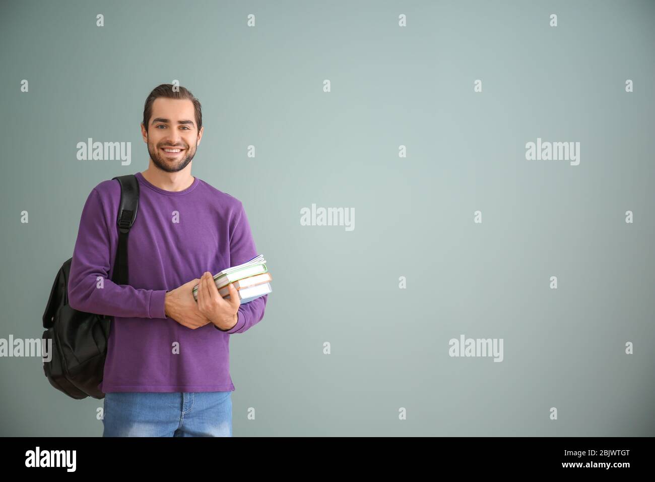 Student with notebooks on color background Stock Photo - Alamy