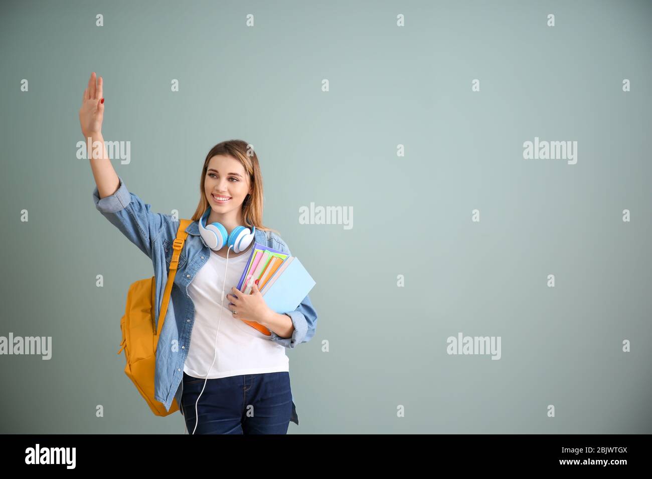 Pretty student with notebooks on color background Stock Photo - Alamy