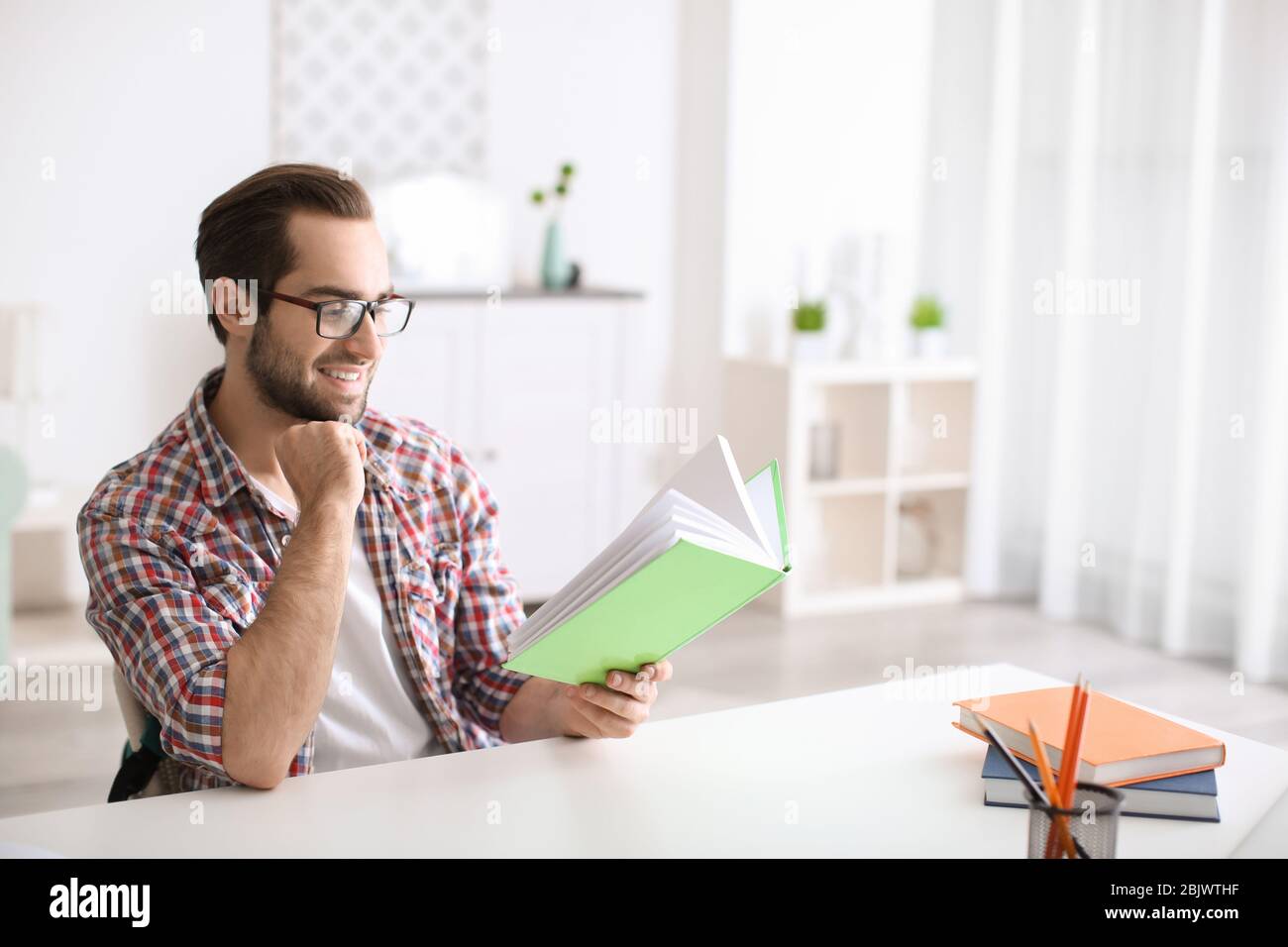 Student studying at table indoors Stock Photo - Alamy
