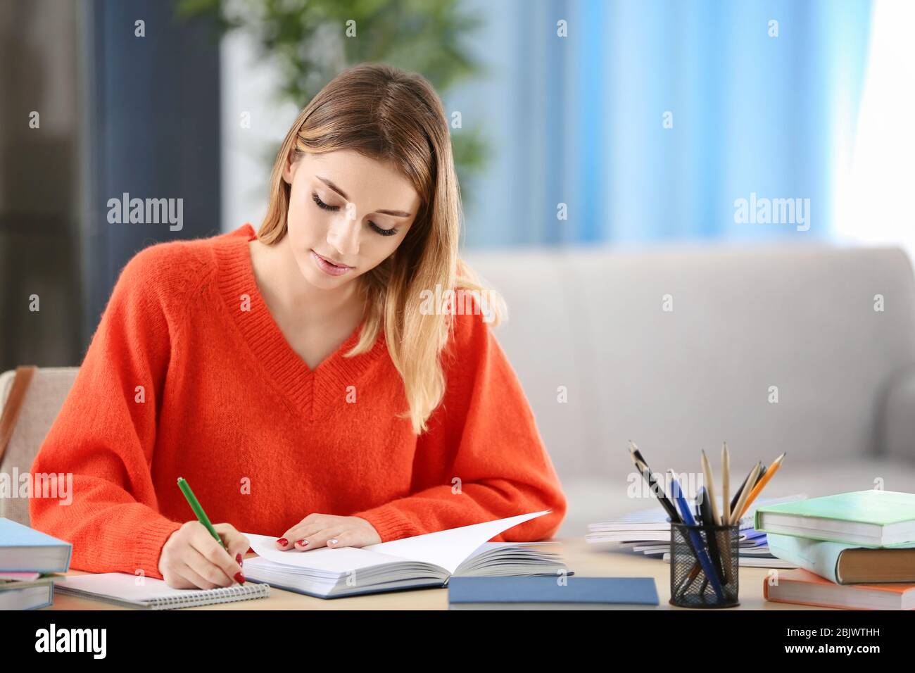 Pretty student studying at table indoors Stock Photo - Alamy