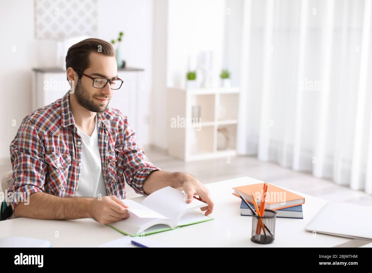 Student studying at table indoors Stock Photo - Alamy