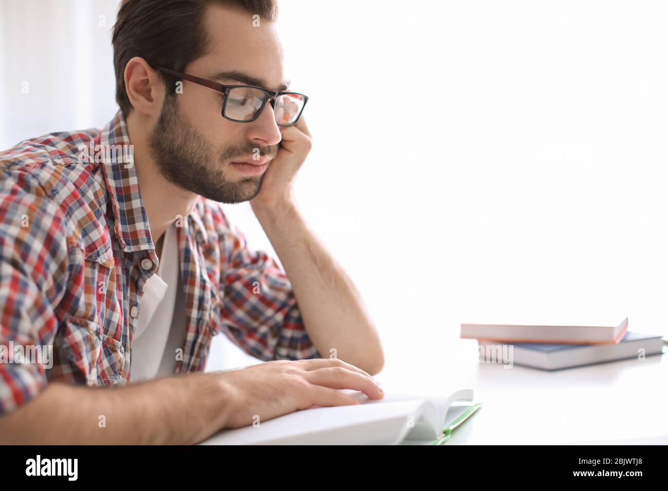 Tired student studying at table indoors Stock Photo - Alamy