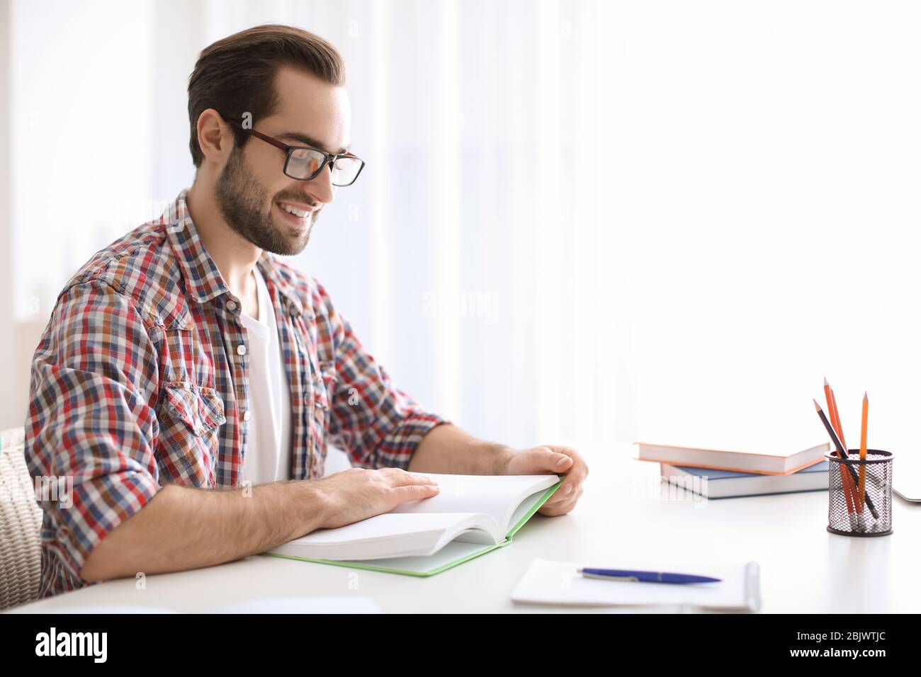 Student studying at table indoors Stock Photo - Alamy